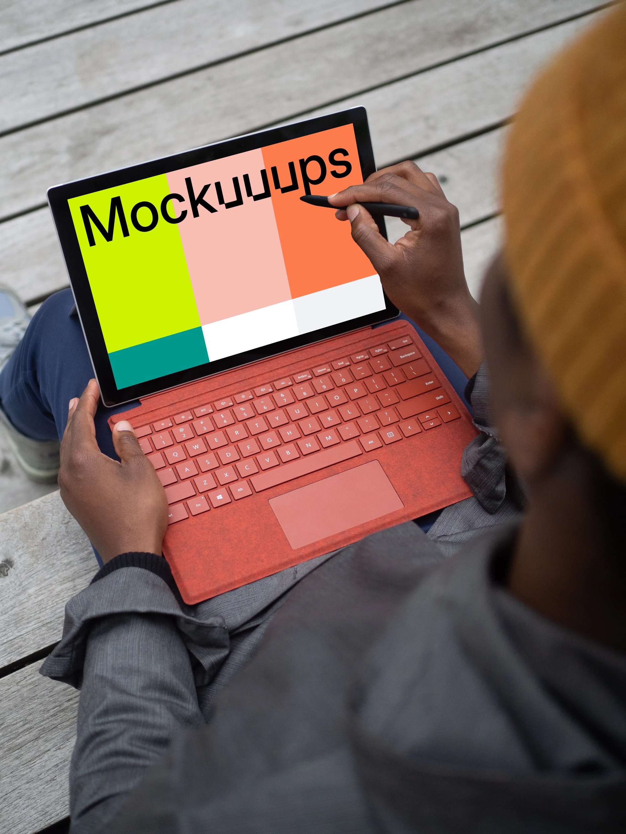 Red Microsoft Surface Laptop mockup held in a users lap - Mockuuups Studio