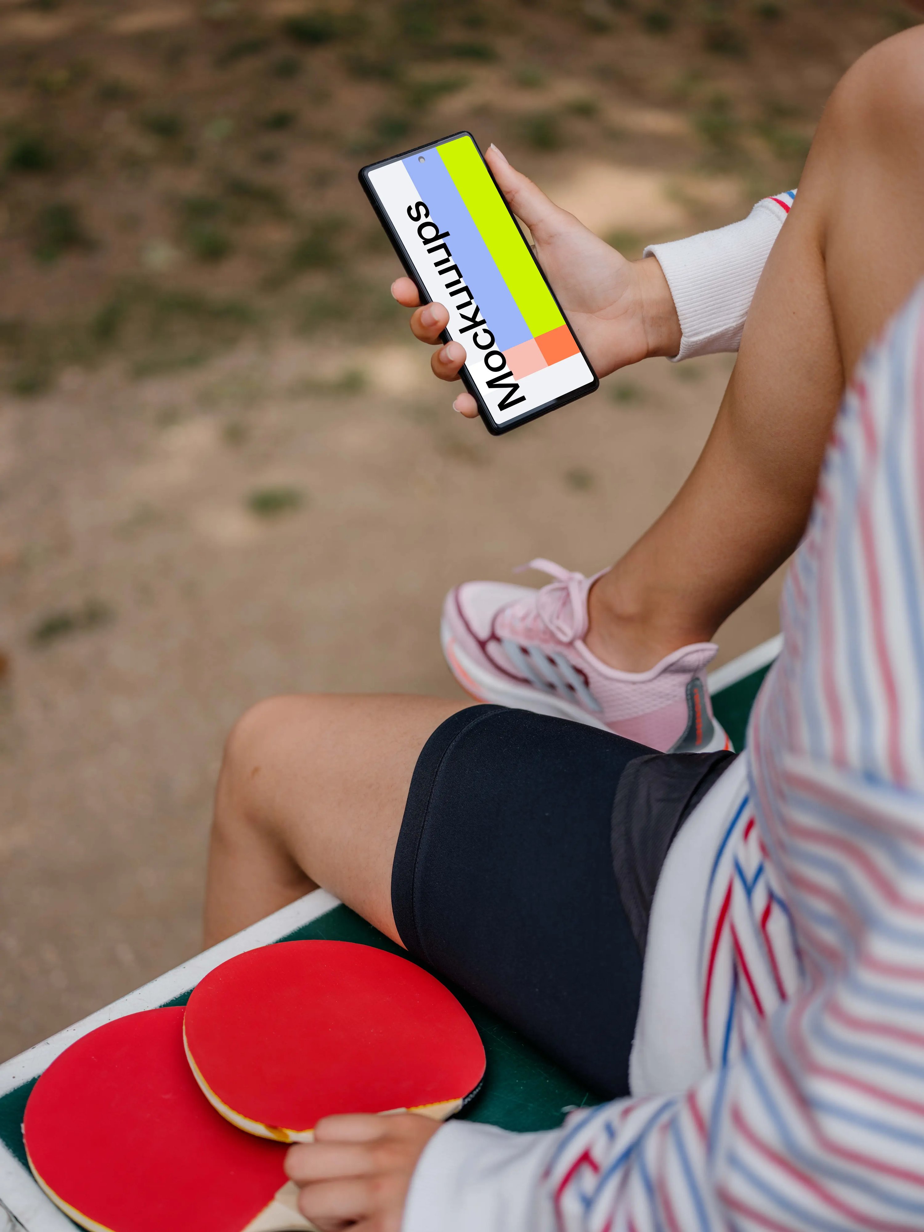 Ping-pong player reading on the smartphone mockup - Mockuuups Studio